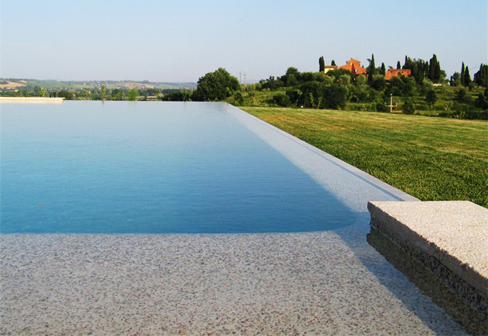 Beach overflow swimming pool coated in stone by Indalo Piscine | STYLEPARK