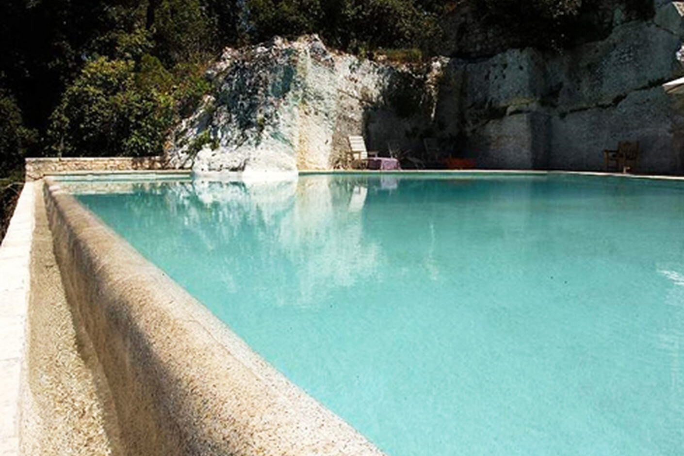 Overflow swimming pool with stone trim by Indalo Piscine | STYLEPARK